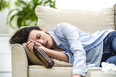 그녀의 손에 빈 병을 가진 의식이 술에 취한 여자는 소파에 누워있다 닫아 가정 생활에 대한 스톡 사진 및 기타 이미지 가정 생활 건강에 좋지 않은 음식 건강한 생활