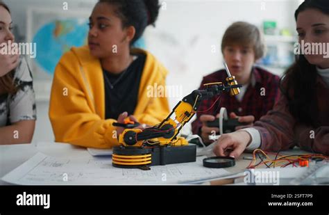 Group Of Students Building And Programming Electric Toys And Robots At