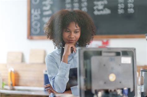 성공한 젊은 바리스타 여성이 카페의 바 카운터에 서 있다 작은 스타트업 소유자 개념입니다 앞치마를 두른 행복한 커피숍 여자