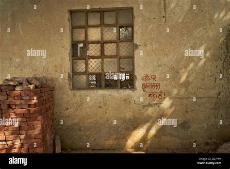 A Pile Of Bricks Lies Next To An Unmaintained House The Wall Reads Do