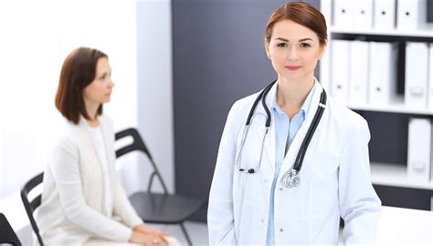 직장에서 의사 여자입니다 여성 의사 진료소 또는 응급 병원 리셉션 데스크 근처에 서 있는 동안 웃 고 명랑 한의 초상화 환자