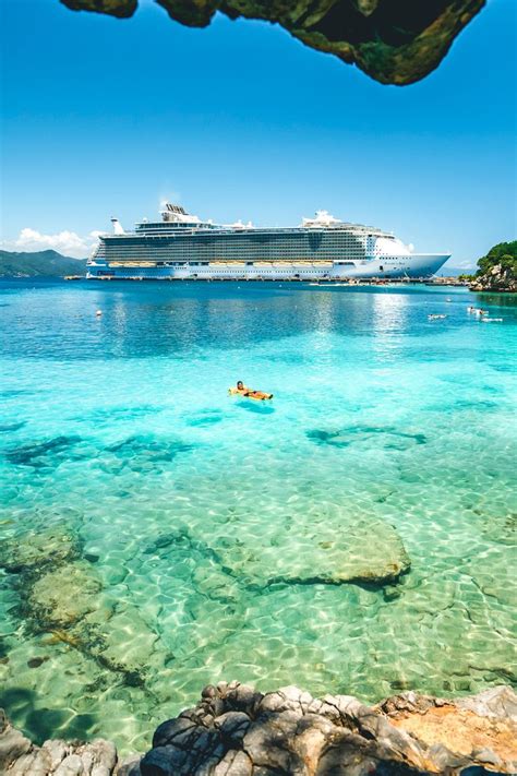 A Cruise Ship Is In The Distance As People Are Kayaking Through Clear