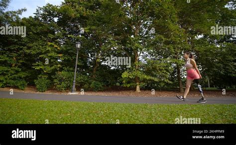 Amputee Asian Girl Walking In Nature Park From Right To Left Early