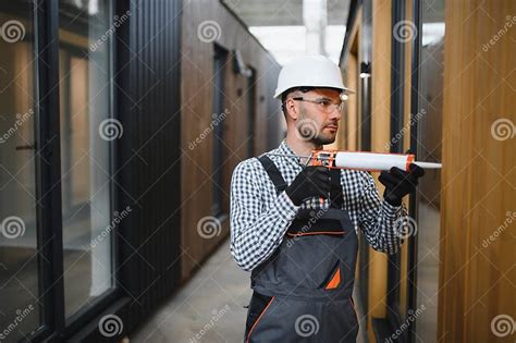 A Worker Is Applying Polyurethane Foam To Fill Gap Between Sash And