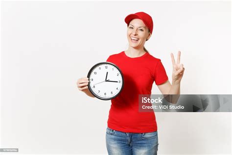 흰색 배경에 고립 된 빨간 유니폼에 배달 여자 모자 티셔츠 전문 여성 청바지 택배 또는 딜러로 일하고 지주 라운드 시계 시간에