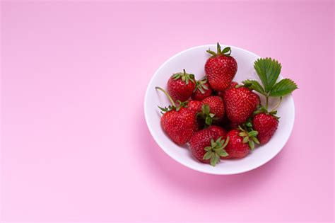 흰 그릇에 수분이 많은 딸기와 분홍색 배경에 녹색 잎 공간을 복사합니다 0명에 대한 스톡 사진 및 기타 이미지 0명 개념