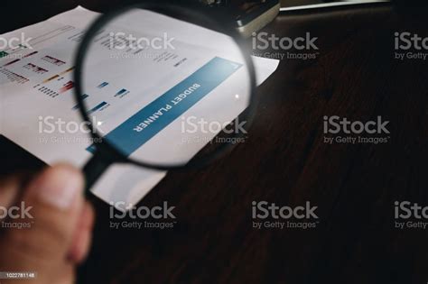 감사 손을 보고 및 분석 재무 데이터 비즈니스 재정 예산 플래너에 돋보기를 개최 하 고 개념을 저장 세금에 대한 스톡 사진 및