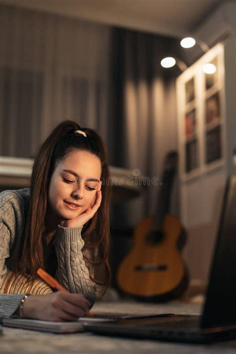 Girl Learning On Line With Headphones And Laptop Taking Notes In A