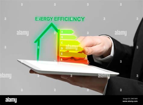 Energy Efficiency Rating Coming Out Of Tablet Man Using Device On