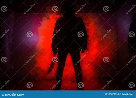 A Dangerous Hooded Man Standing In The Dark And Holding A Knife Face