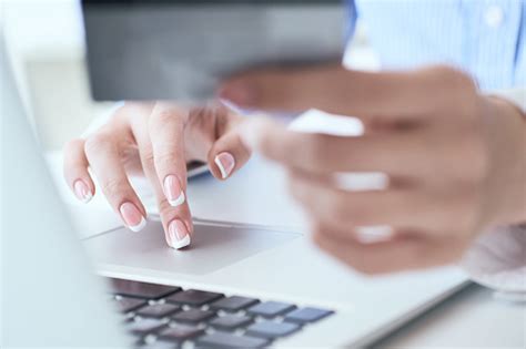 사무실 테이블에 앉아있는 동안 노트북 키보드에 신용 카드와 입력 번호를 들고 여성의 손 선택적 초점 고객에 대한 스톡 사진 및