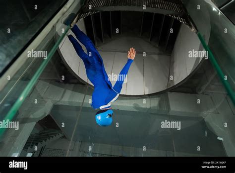 A Man In Overalls And A Protective Helmet Enjoys Flying In A Wind