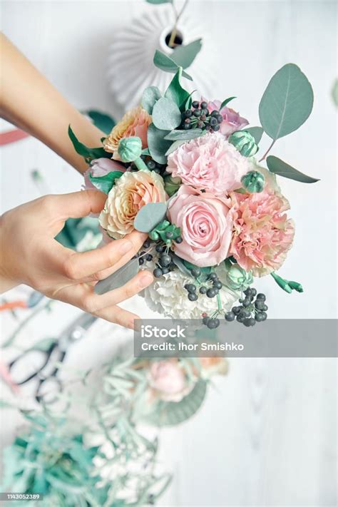 직장에서 여성 꽃집의 수직 이미지입니다 꽃다발에 다양 한 꽃을 배치 평면도 마스터 클래스 또는 과정에서 플로리스트 교사 직업적인