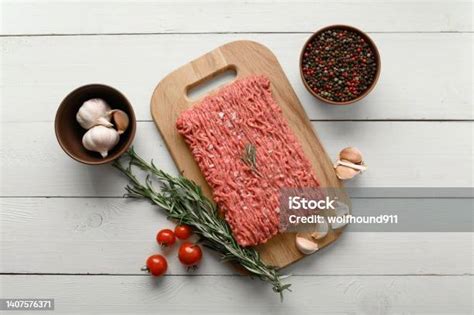 신선한 생고기 또는 백리향 향신료 및 마늘이있는 나무 커팅 보드에 닭고기를 갈아 넣으십시오 흰색 나무 배경 상단 보기 공간을