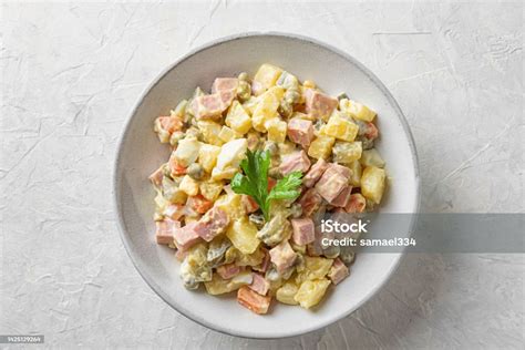 전통적인 러시아 또는 우크라이나 샐러드 올리비에 삶은 야채와 흰색 테이블에 마요와 소시지 위쪽 보기 러시아식 샐러드에 대한 스톡