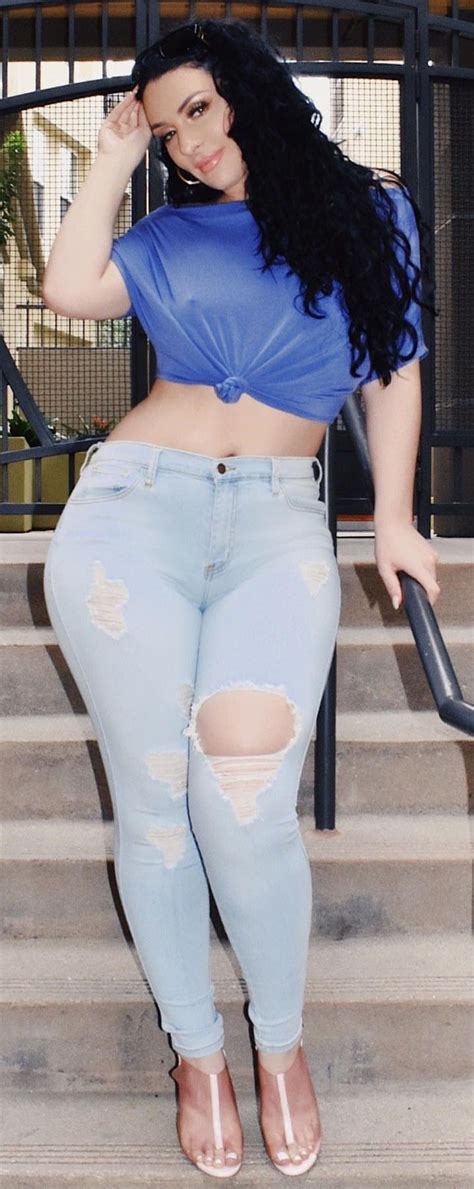 A Woman In Ripped Jeans And Heels Standing On Steps With Her Hands