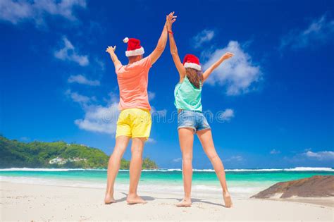 Young Couple In Santa Hats Having Funon Tropical Beach New Year