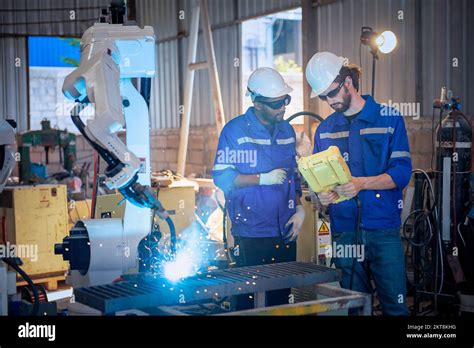 Two Engineers Mechanic Using Computer Controller Robotic Arm For