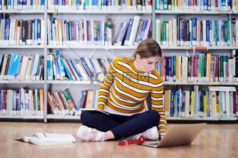 女学生在图书馆的一本书上做笔记。高清摄影大图 千库网