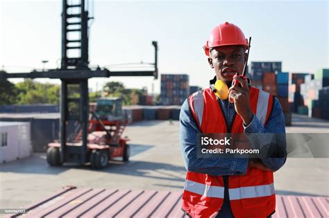 워키토키 무선 제어 적재 컨테이너 상자를 사용하는 감독 엔지니어 컨테이너 화물 현장에서 헬멧 작업을 통한 자신감 있는 엔지니어링 및 산업용 컨테이너 화물 운송 선박 점검