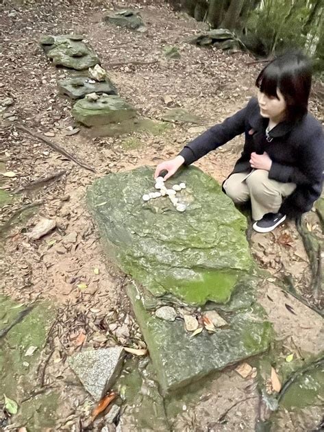 隠れキリシタンの墓に載せられた白い石で十字架を作る林田さん 母なるキリスト「沈黙」に 遠藤周作、日本人に合う宗教追い 写真・画像2