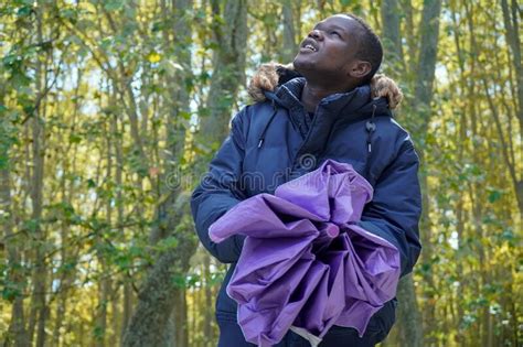 African Man With A Closed Umbrella In Nature Looking Up Wintertime