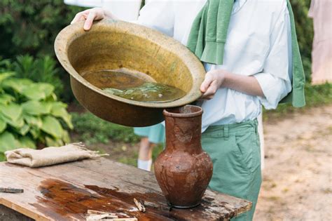 소년은 찰 흙 주전자 구리 분 지에 그것을 밖으로 쏟아지는 물 보유 하고있다 도움말 건조한에 대한 스톡 사진 및 기타 이미지 건조한 구리 나무 Istock