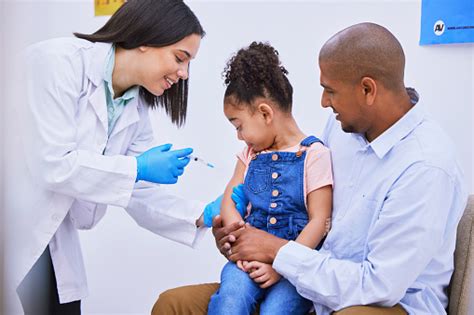 병원이나 병원에서 백신 독감 예방 주사 또는 약 주사를 위한 주사기를 가진 어린이 아빠 및 여성 의사 아버지 소녀 소아과 의사가