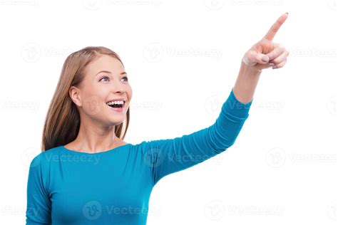 Over There Beautiful Young Woman Pointing Away And Smiling While Standing Against White