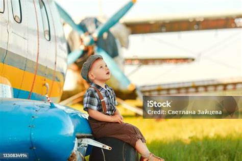 한 어린이가 오래된 비행기 근처에 서서 자라면서 조종사가 되는 꿈을 꾸고 있습니다 미래의 직업을 선택하는 개념 2 3 살에 대한 스톡 사진 및 기타 이미지 Istock