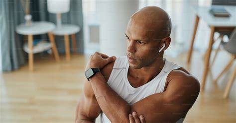 아프리카 계 미국인 운동 선수는 가정 운동을 위해 워밍업하고 팔을 뻗습니다 사진 Unsplash의 사진술 이미지