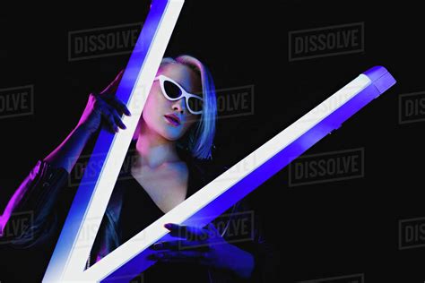 Beautiful Stylish Model In Sunglasses Posing With Two Ultraviolet Lamps