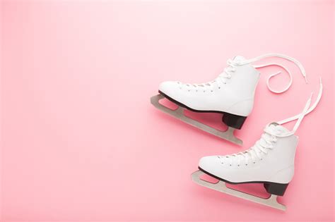 밝은 분홍색 테이블 배경에 흰색 여성 피겨 스케이트 파스텔 색상 활동을 위한 스포츠 액세서리 근접 촬영 텍스트의 빈 장소입니다