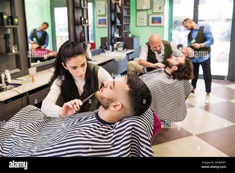 From Above Of Male And Female Barbers Adjusting Beards Of Clients