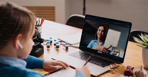 십대 초반의 한 소년이 노트북을 사용하여 선생님과 화상 통화를 합니다 화면에는 수업에서 주제를 설명하는 교사와 함께 온라인 강의가 표시됩니다 사진 Unsplash의