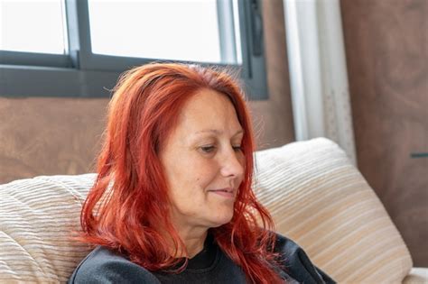 Premium Photo Smiling Redhead Woman Sitting On Sofa At Home