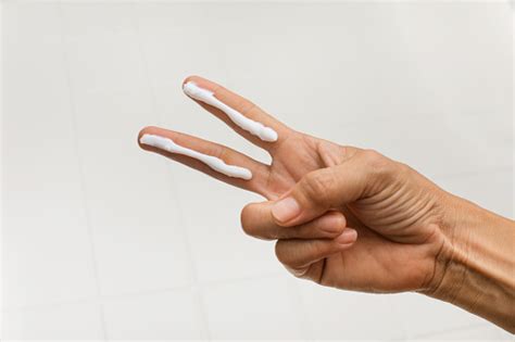 두 손가락으로 자외선 차단제를 사용하십시오 얼굴과 목에 정확한 양의 자외선 차단제를 바르십시오 햇볕 차단 로션에 대한 스톡 사진 및 기타 이미지 Istock