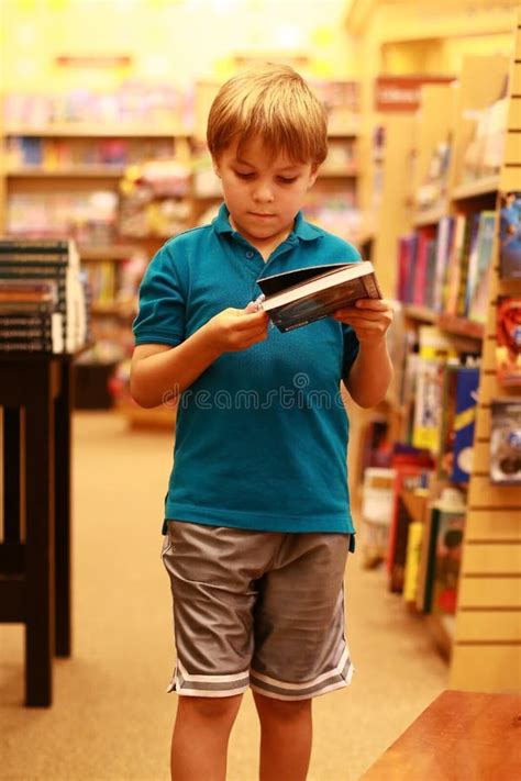 Libro De Lectura Del Muchacho En La Biblioteca O El Almacén De Libro