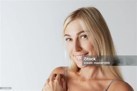 긴 금발 머리를 가진 젊은 예쁜 여자의 클로즈업 초상화 미소 짓고 행복하고 편안한 얼굴 표정으로 카메라를 바라 봅니다 여자에