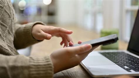Premium Photo A Woman Using Her Smartphone While Working On Her Tasks At Her Desk