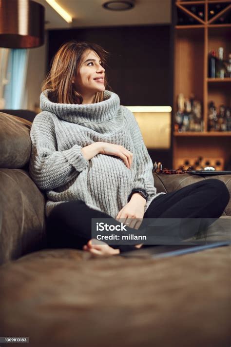 귀여운 임신 한 여자는 그녀의 집에서 소파에 앉아 배를 껴안고 가정 생활에 대한 스톡 사진 및 기타 이미지 가정 생활 기대