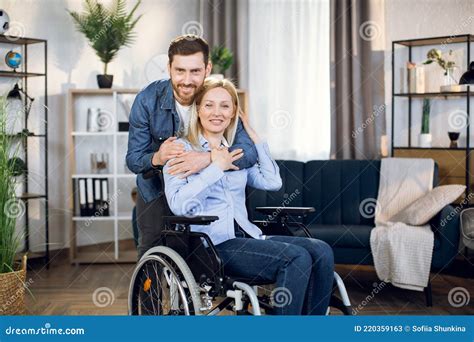 Kvinna Som Sitter I Rullstol Medan Man Kramar Henne Bakom Fotografering