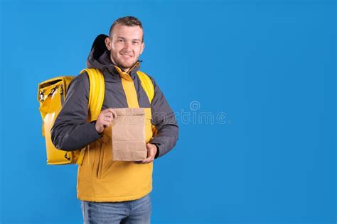 Young Smiling Caucasian Food Delivery Man In Yellow Uniform And Cooler