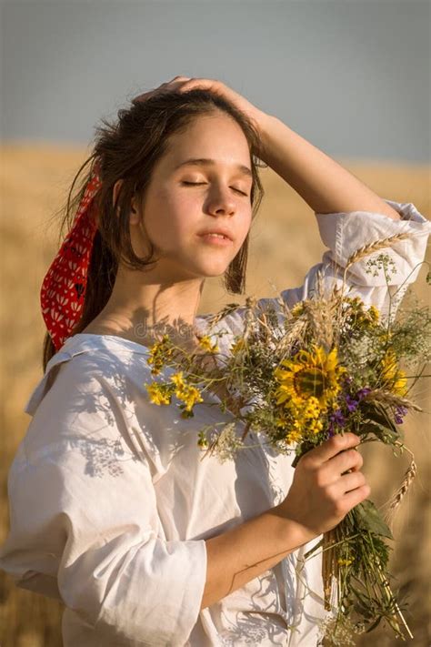 Chica En Un Campo De Paja Con Un Ramo De Flores Silvestres A Mano Foto De Archivo Imagen De