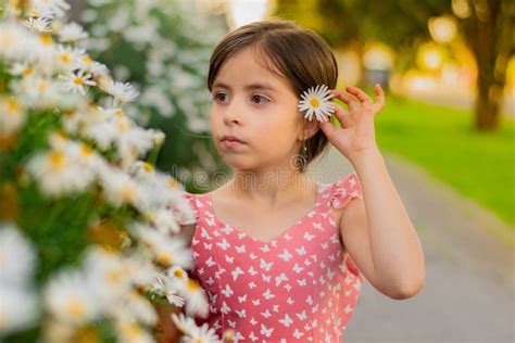 Long Haired Colombian Girl Smells The Flowers Of The Garden In The
