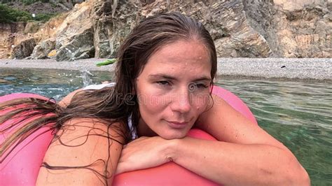 Summer Vacation Woman Floats On An Inflatable Donut Mattress A Water