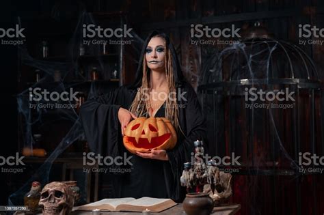 할로윈 개념 검은 마녀 들고 할로윈 호박 과 조각 Smily 얼굴 에 손으로 서 어두운 방 마술사에 대한 스톡 사진 및 기타