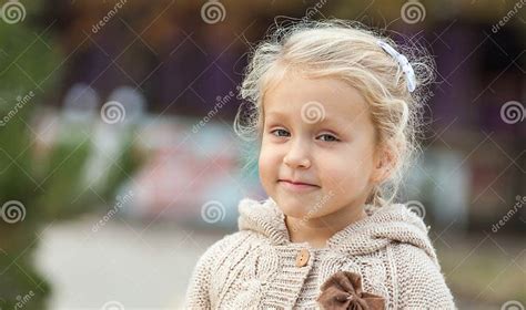 Niña Rubia Con Una Sonrisa Satisfecha En El Parque Para Un Paseo Imagen
