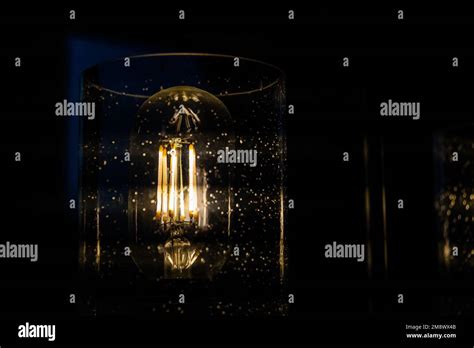 Retro Style Vintage Light Bulb In A Glass Enclosure With Bubble Texture In A Dark Room Stock