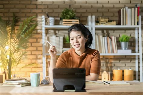 매력적인 스마트 아시아 여성 착용 캐주얼 천 작업 양식 홈 태블릿 기술 장치 아시아 여성 여성 작업 홈 스튜디오 사무실 온라인